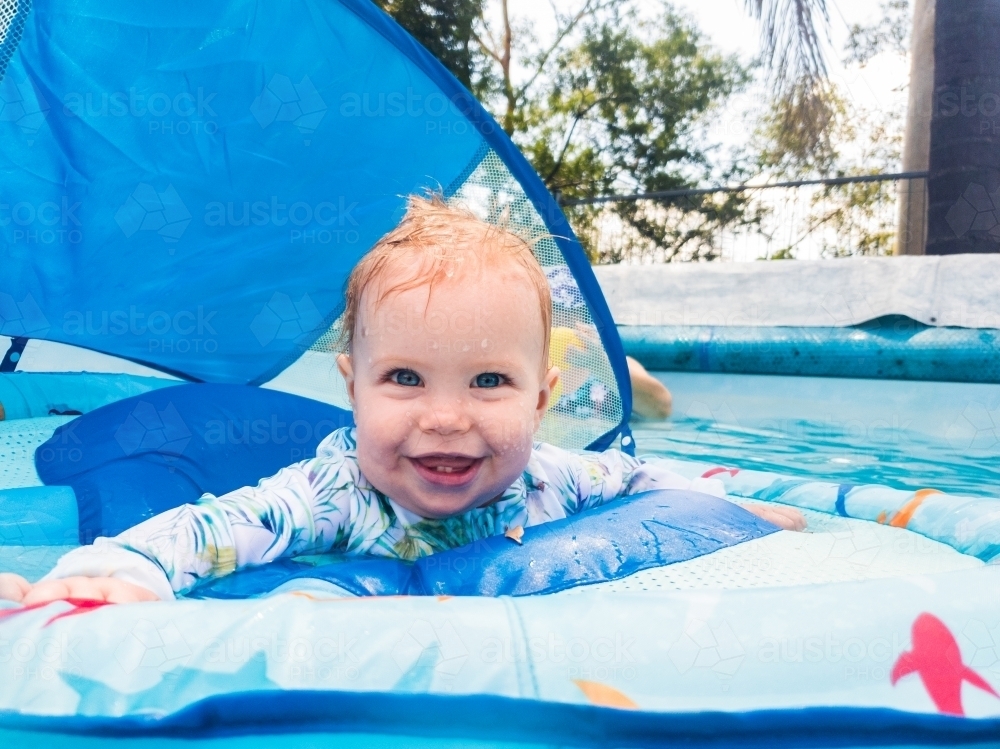 Image of happy baby in backyard pool in summer enjoying splashing and ...