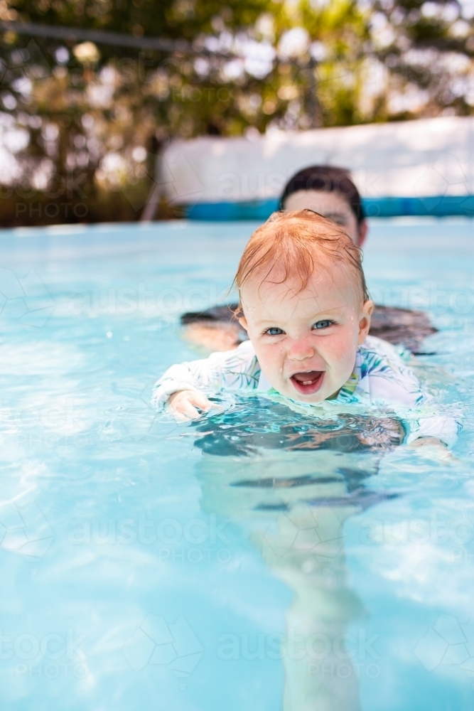 Image of Happy baby splashing and swimming in private pool - Austockphoto