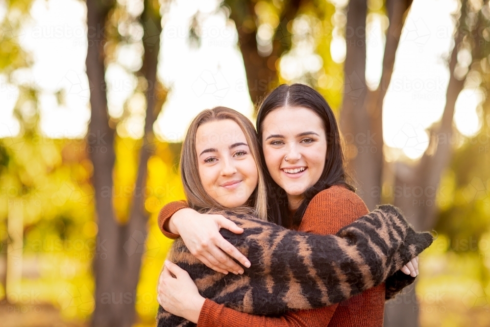 Image of happy best friends with arms around each other - Austockphoto