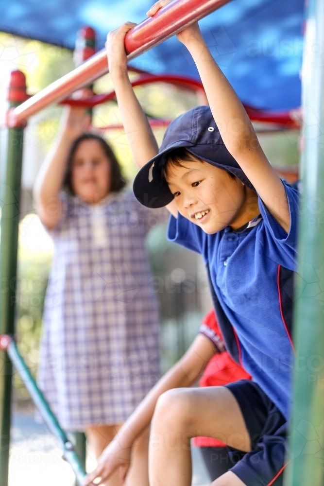 Image of Happy boy primary school student climbing on the play ...