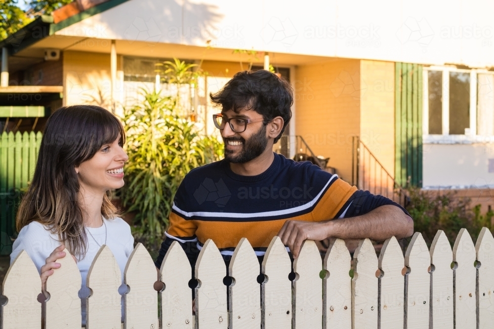 Image of happy couple in front of their home - Austockphoto
