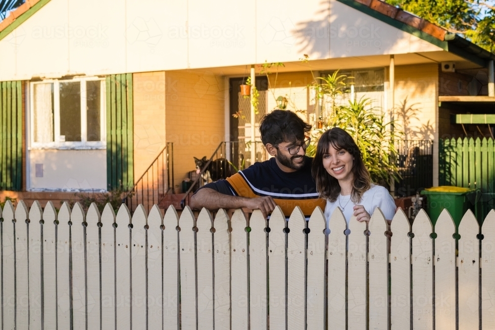Image of happy couple in front of their home - Austockphoto