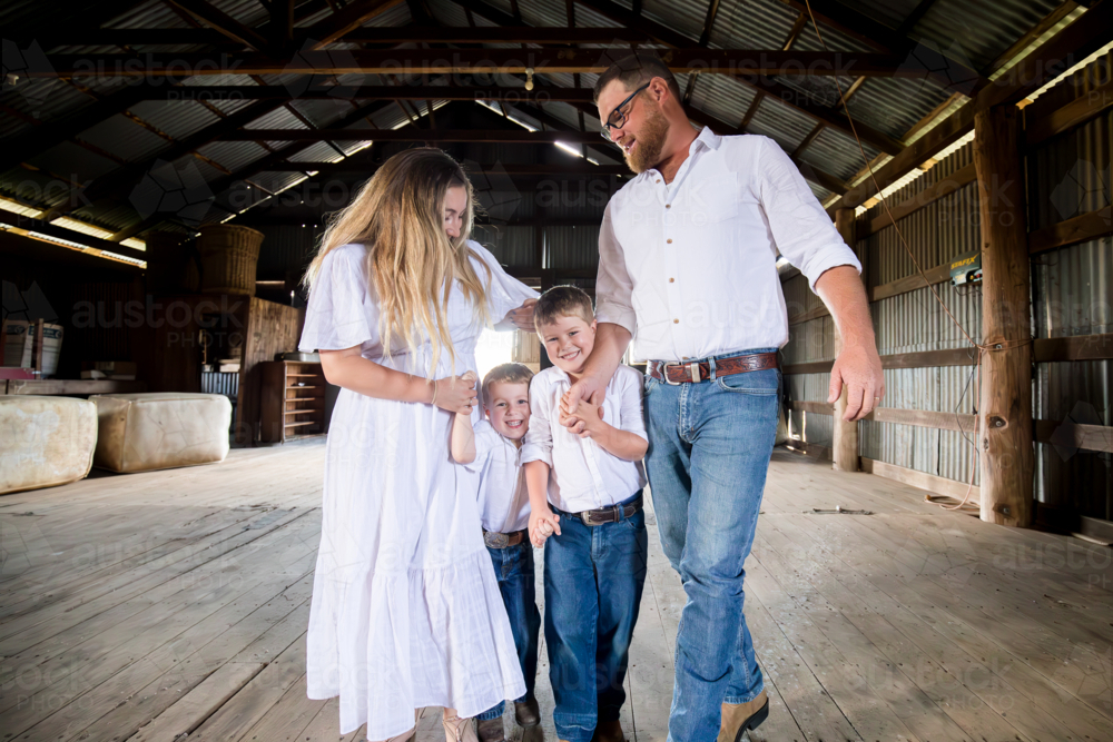Image of Happy family of four in rustic Australian shearing shed on ...