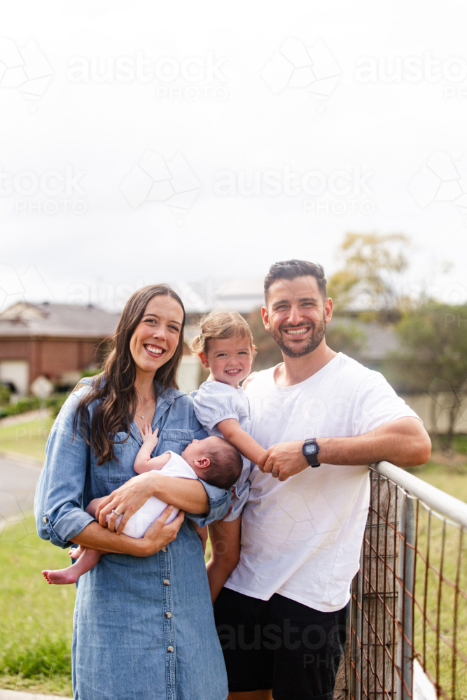 Image of Happy family with newborn baby standing outdoors. - Austockphoto
