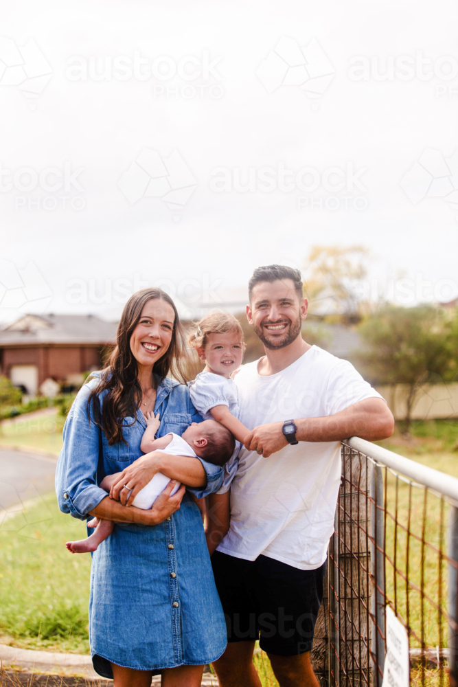Image of Happy family with newborn baby standing outdoors. - Austockphoto