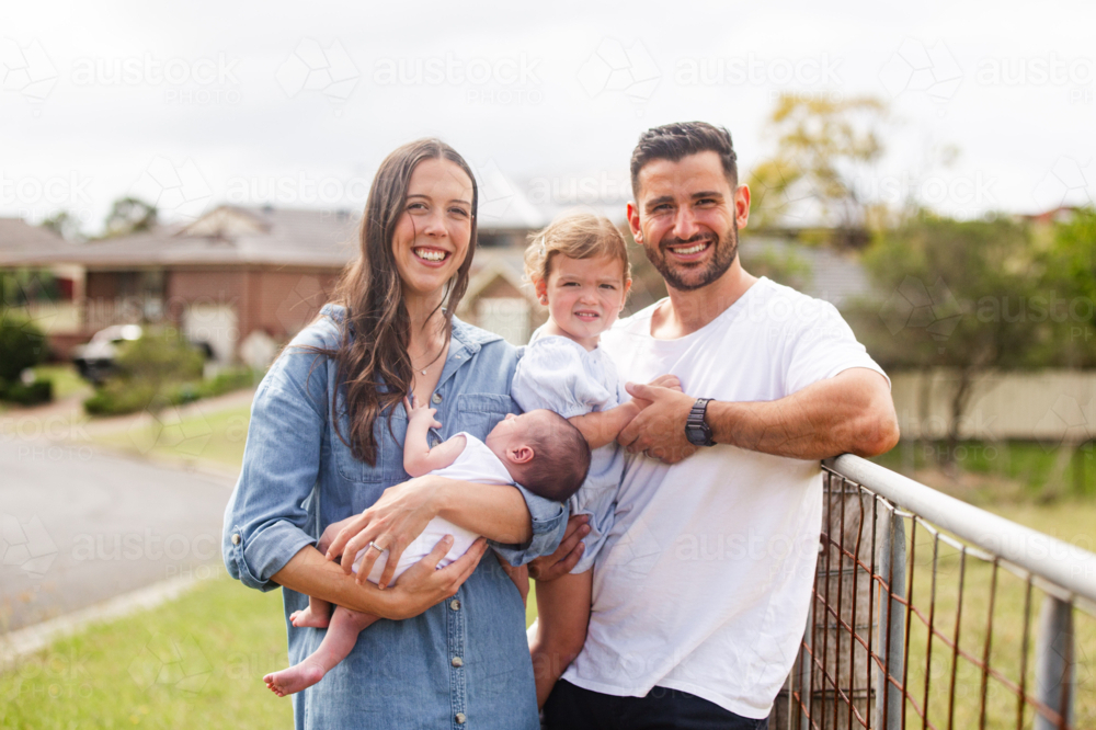 Image of Happy family with newborn baby standing outdoors. - Austockphoto