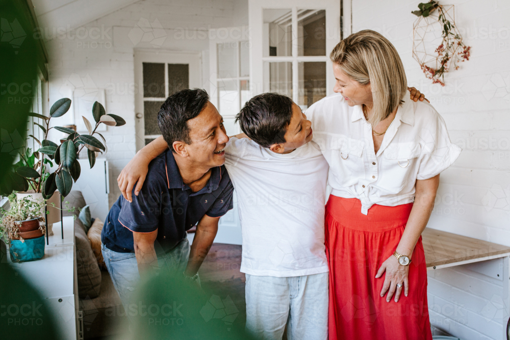 Image of Happy family with young boy embracing his parents inside home ...
