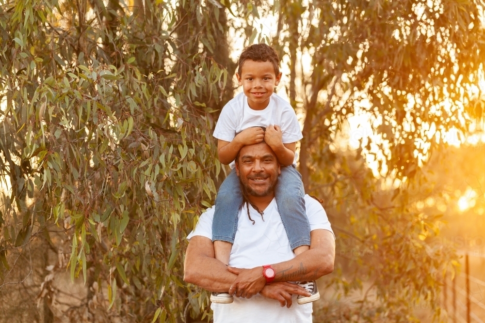 Image of Happy father and son portrait standing by hanging leaves of ...
