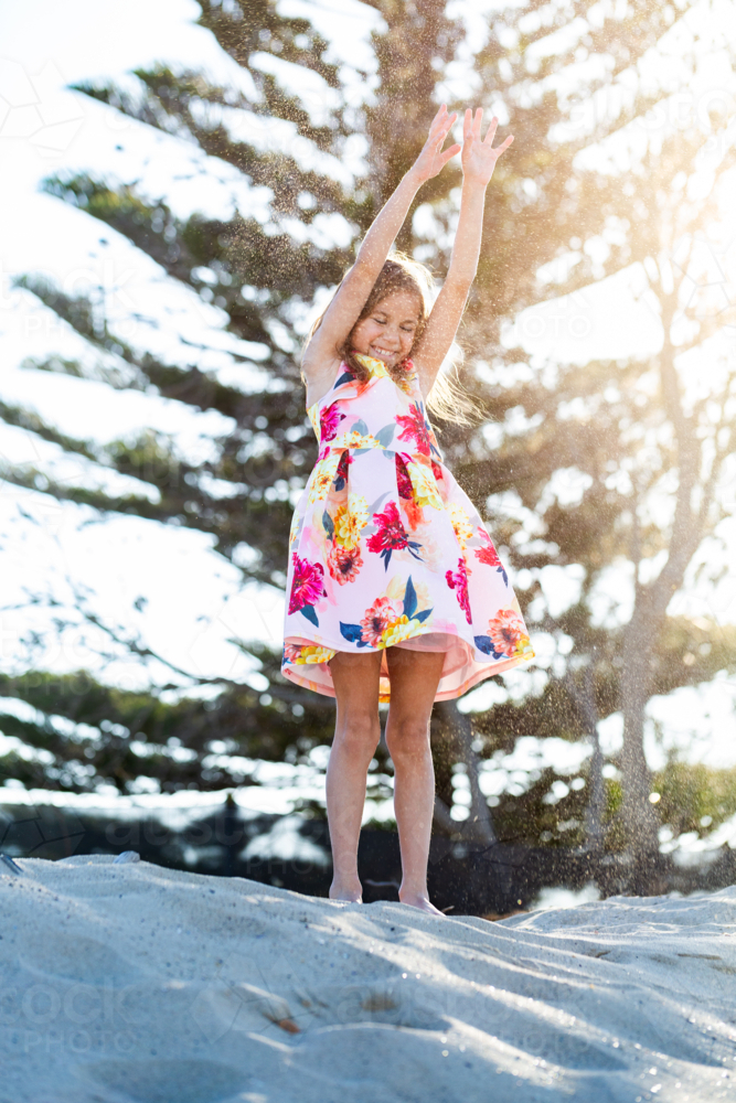 Image of Happy First Nations Australian little girl throwing sand in ...