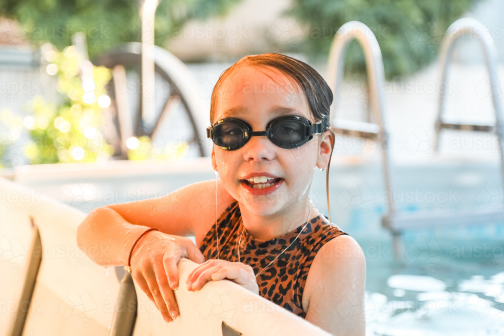 Image of Happy girl swimming in backyard pool - Austockphoto