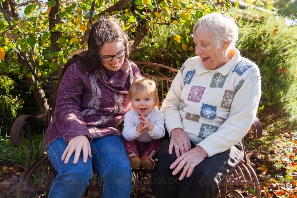 Image of happy great grandbaby with mum and great grandmother on seat ...