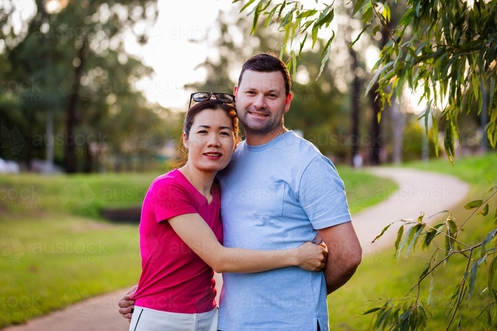Image of Happy interracial Australian couple standing together by path ...