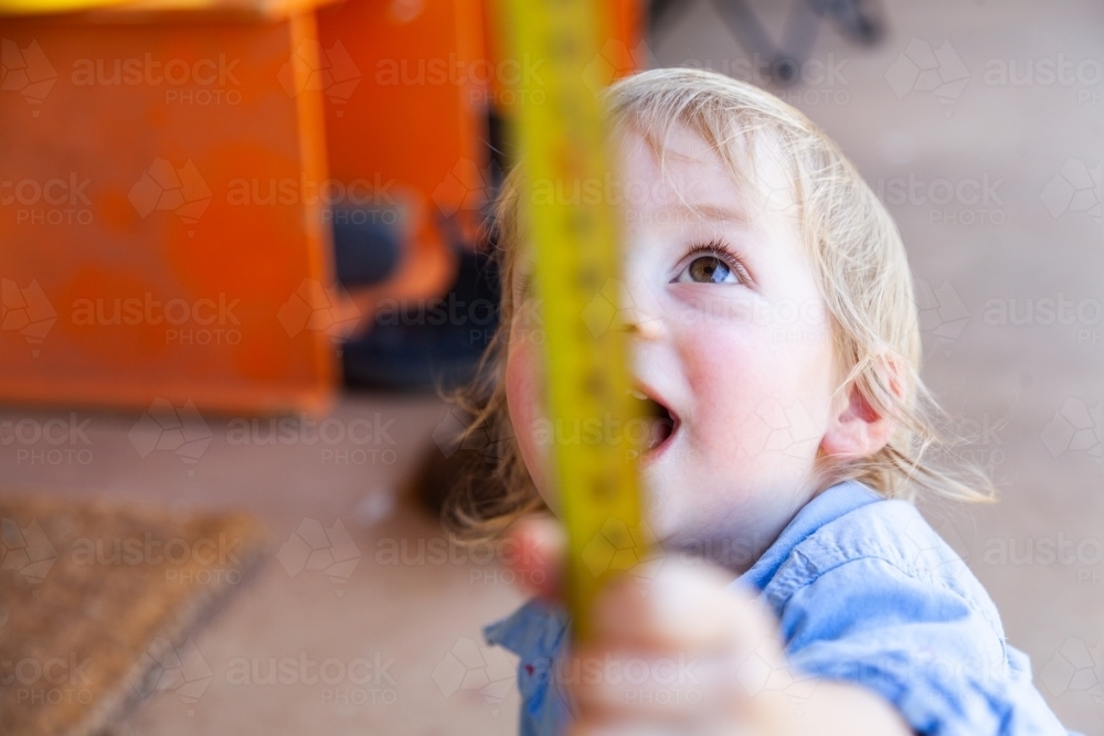 Image of Happy kid with a tape measure - Austockphoto