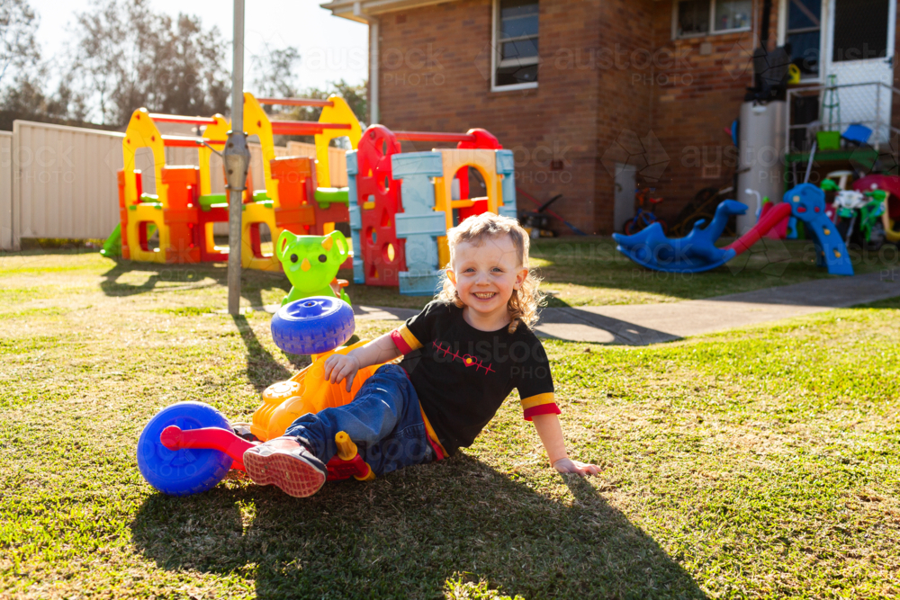 Image of Happy little Aussie kid playing with colourful trike in ...