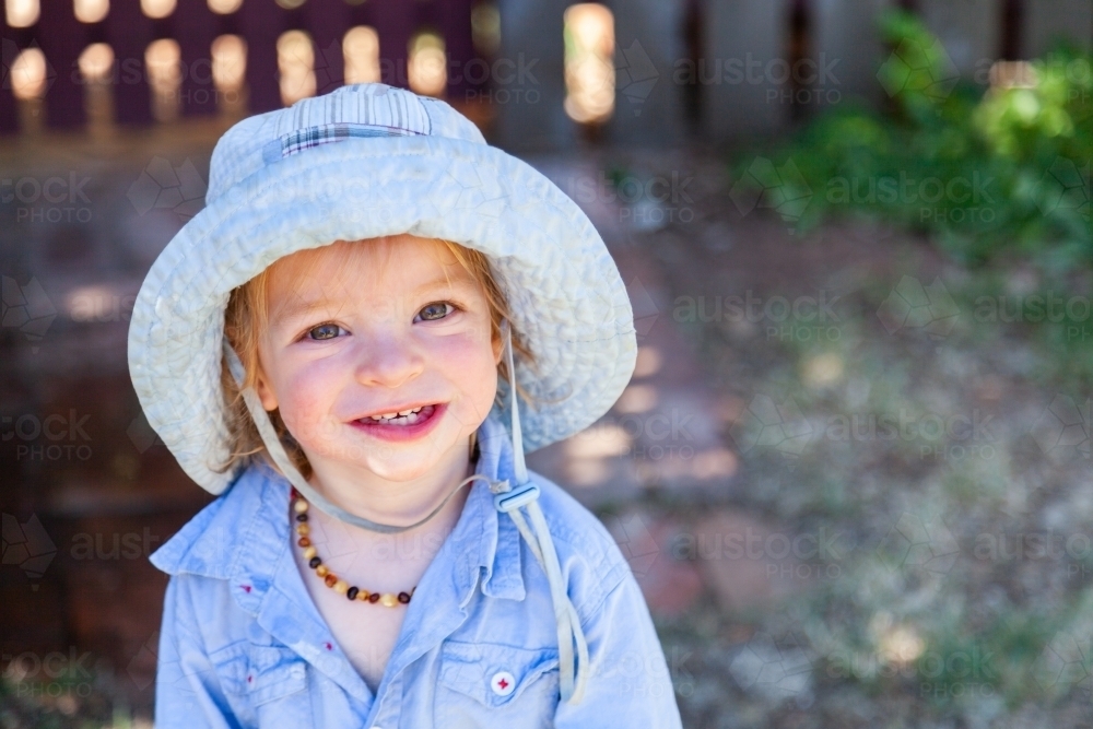 Image of Happy little boy being sun safe with hat on outside - Austockphoto