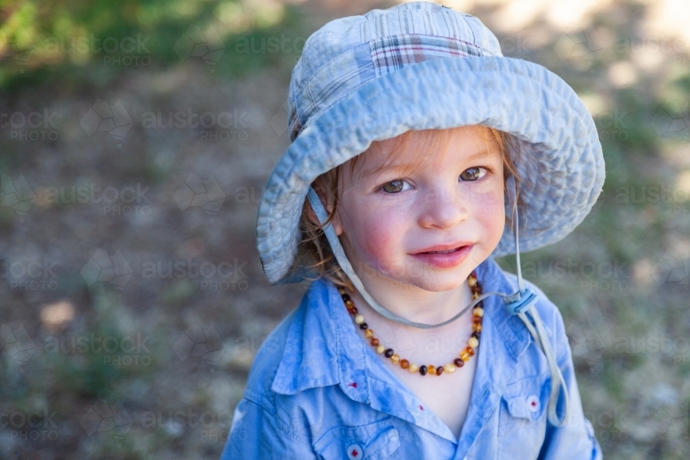 Image of Happy little boy being sun safe with hat on outside - Austockphoto