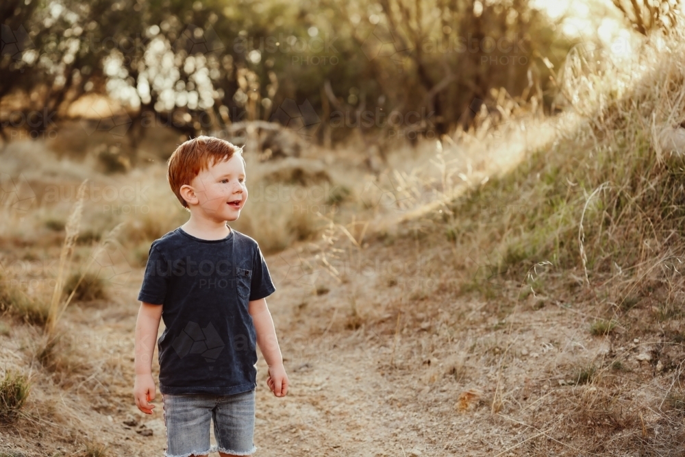 Image of Happy little boy exploring the Australian bush - Austockphoto