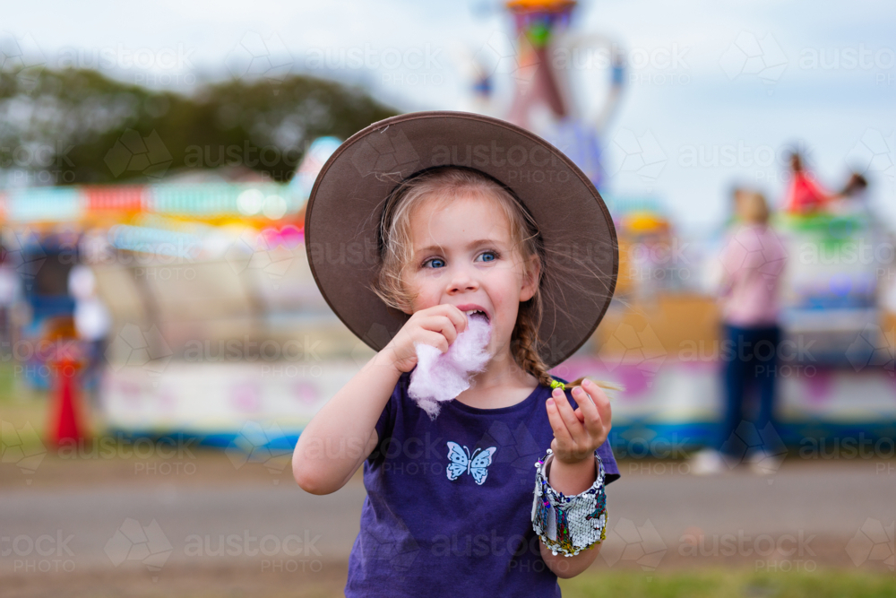 Image of Happy little girl eating pink fairy floss as a treat at local ...