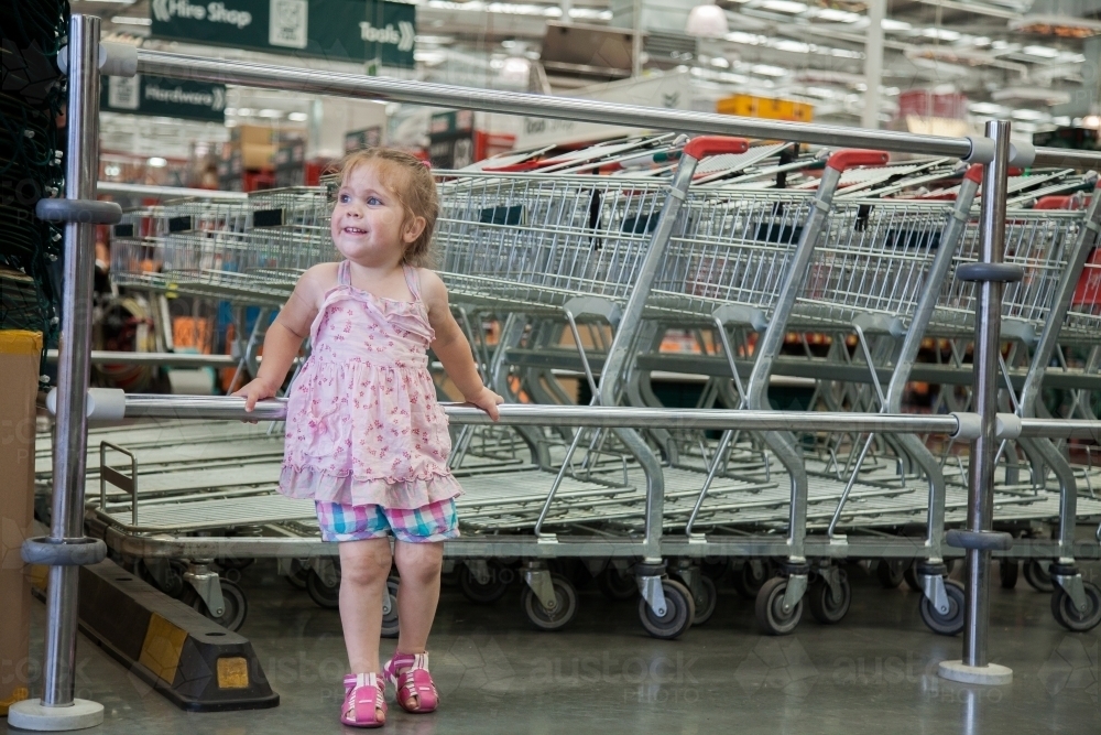 Image of Happy little girl running around in the shops - Austockphoto