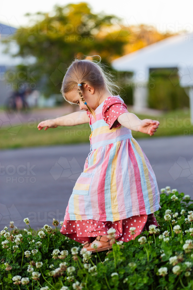 Image of Happy little toddler dancing and twirling outside at dusk in ...