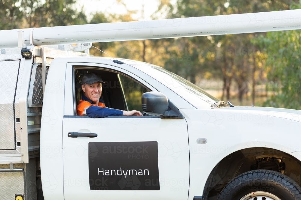 Image of Happy man driving his ute working for himself as handyman in ...