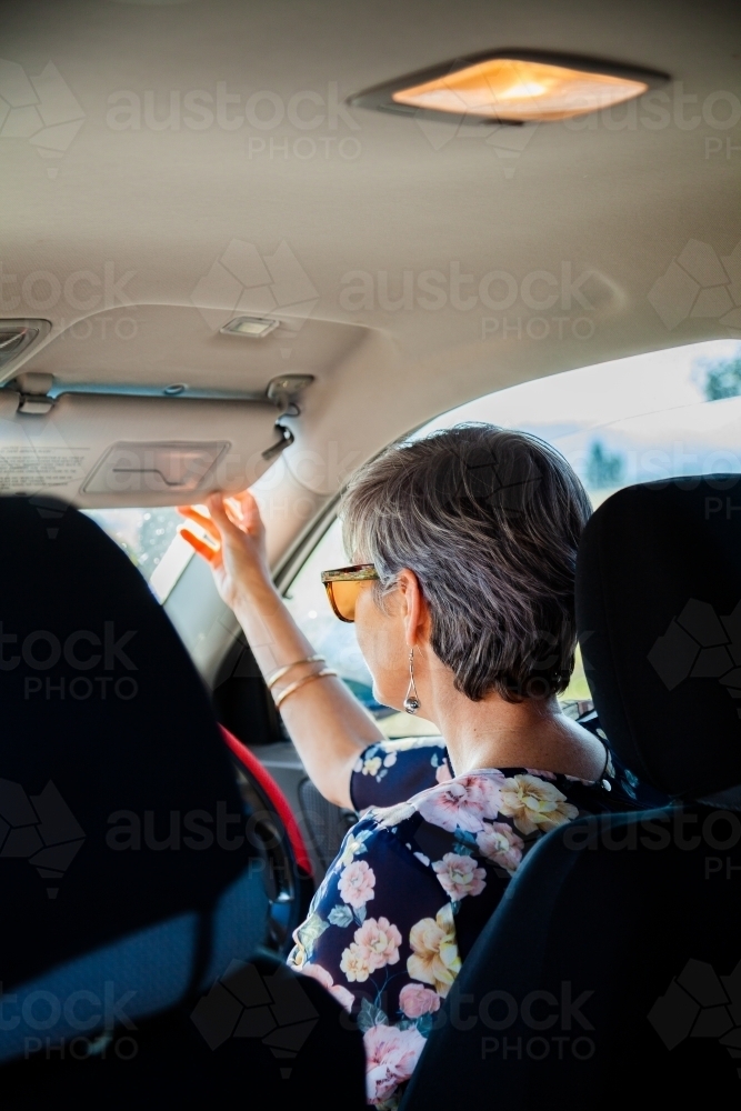 Image of Happy mature aged woman getting into her car - Austockphoto