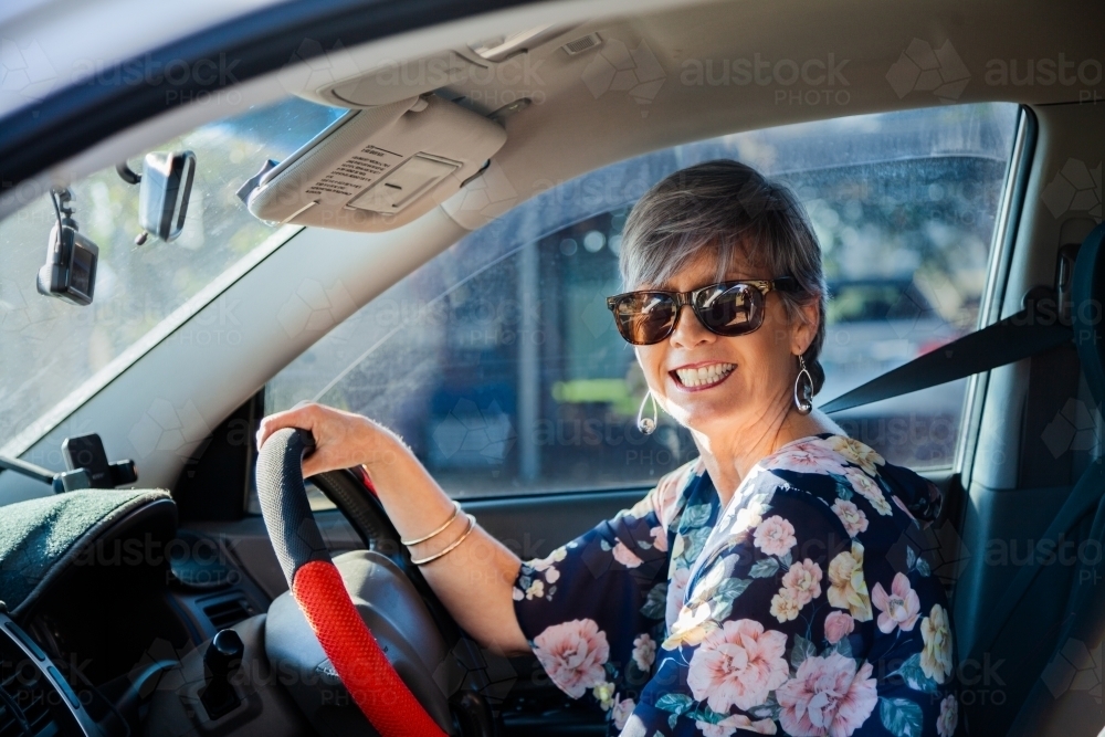 Image of Happy middle aged driver in car with sunnies on - Austockphoto