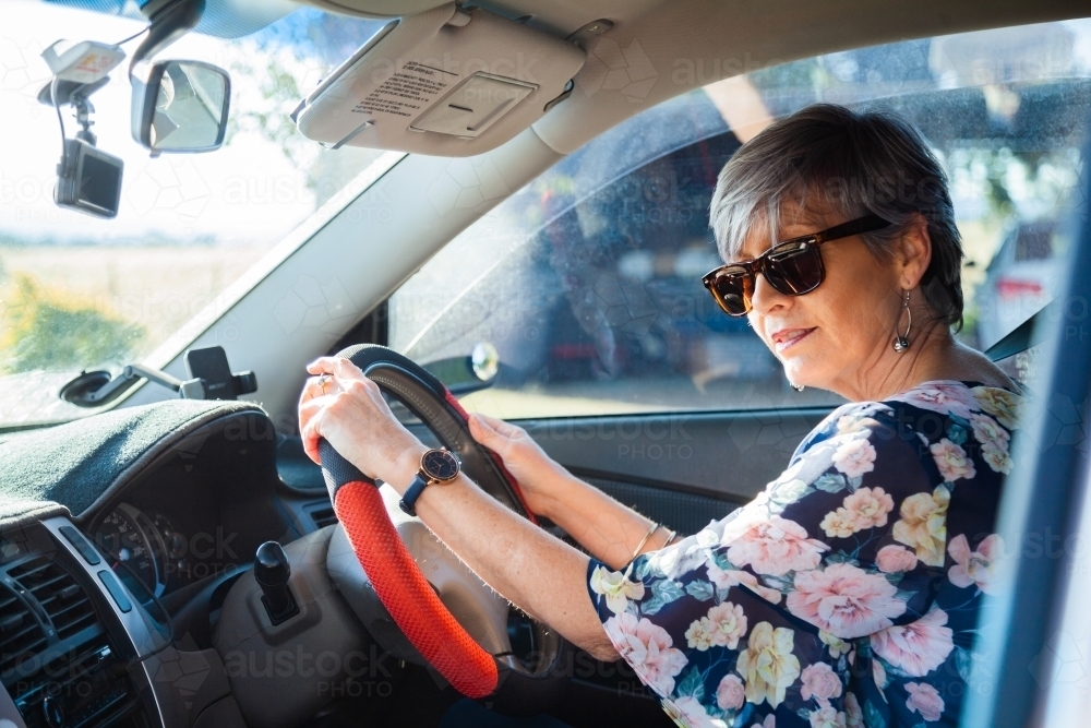 Image of Happy middle aged driver in car with sunnies on - Austockphoto