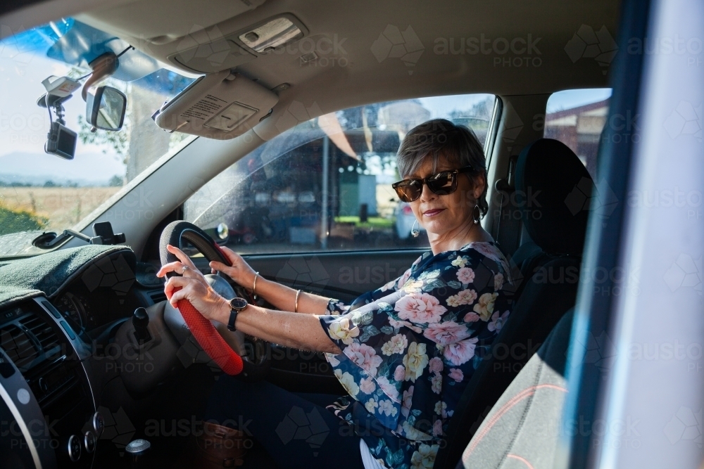 Image of Happy middle aged driver in car with sunnies on - Austockphoto
