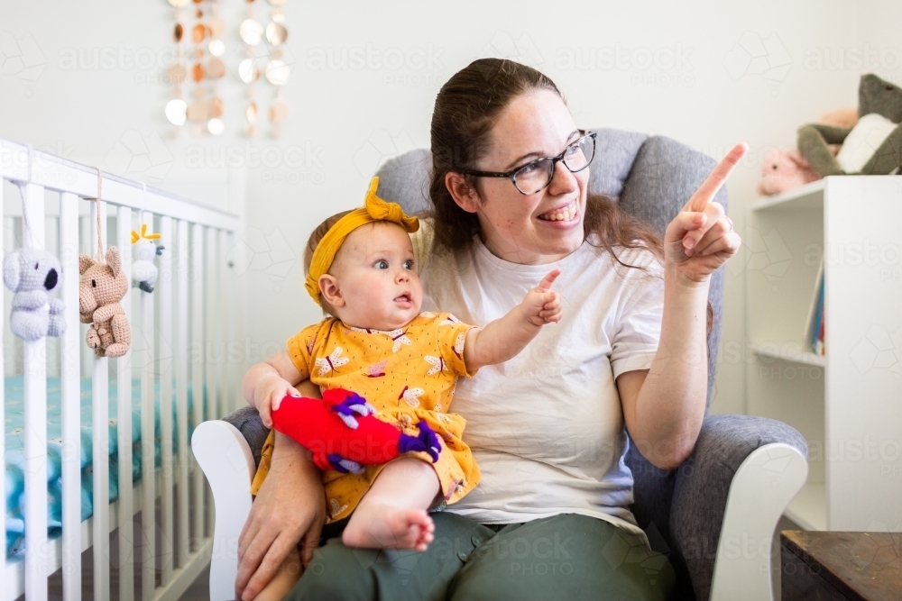 Image of Happy mother and baby with crochet toy in rocking chair ...