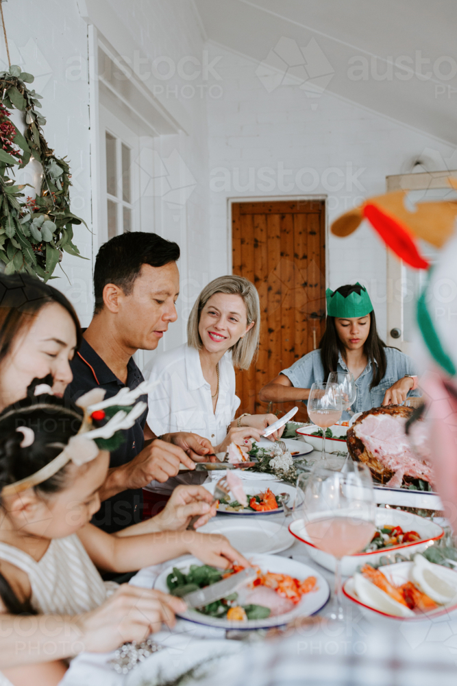 Image of Happy multiracial family enjoying Christmas dinner - Austockphoto