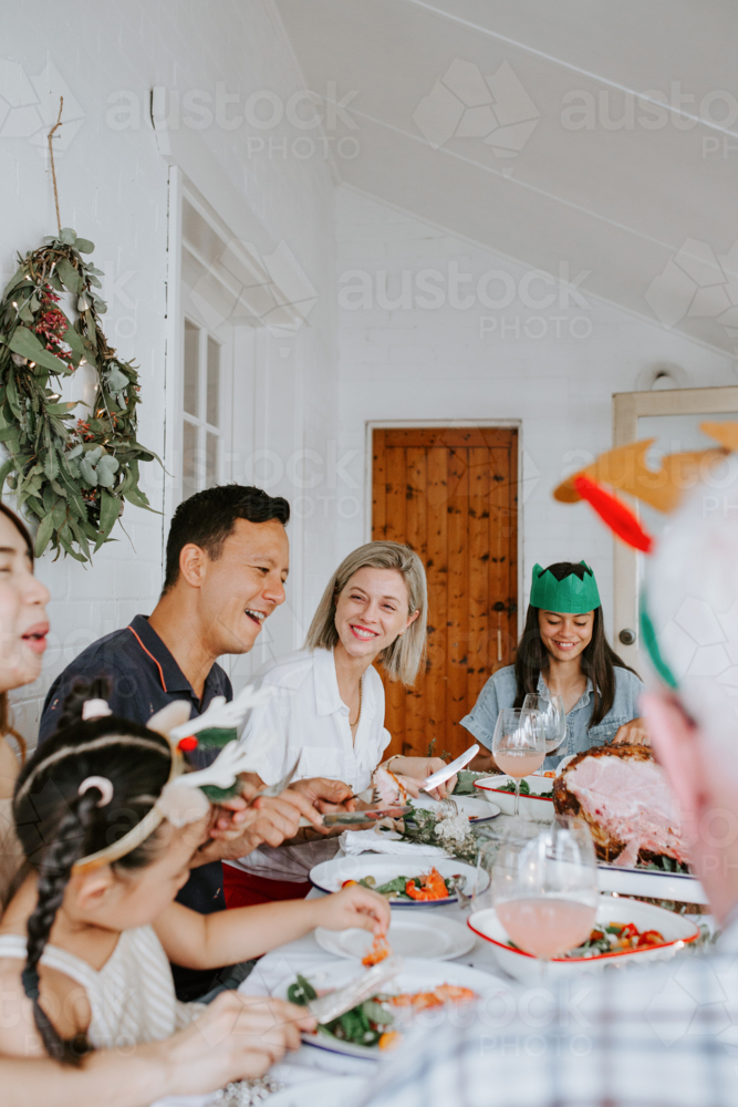 Image of Happy multiracial family enjoying Christmas dinner - Austockphoto