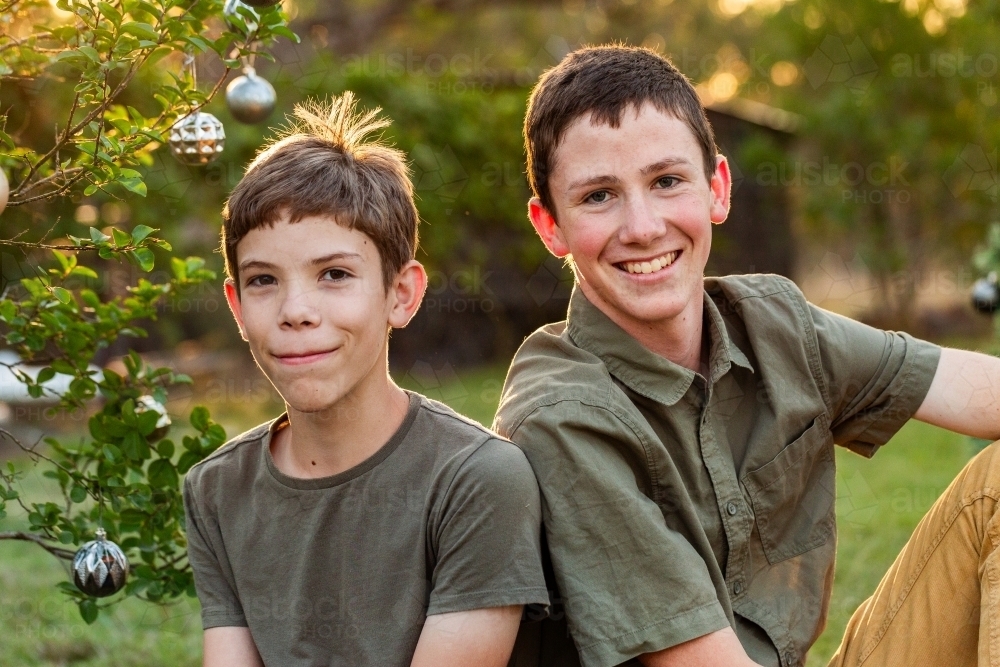 Image of Happy pair of brothers together outside at Christmas wearing ...