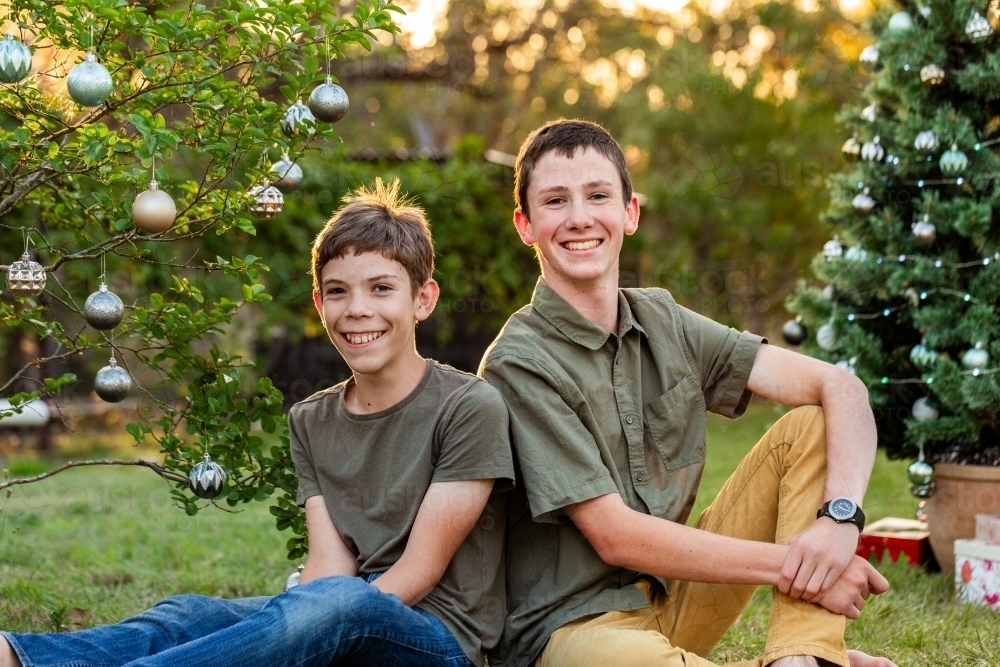 Image of Happy pair of brothers together outside at Christmas wearing ...