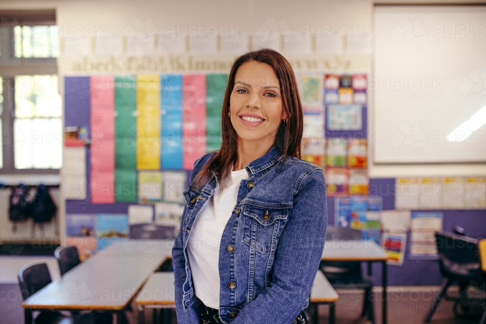 Image of Happy primary school teacher in standing inside the classroom ...