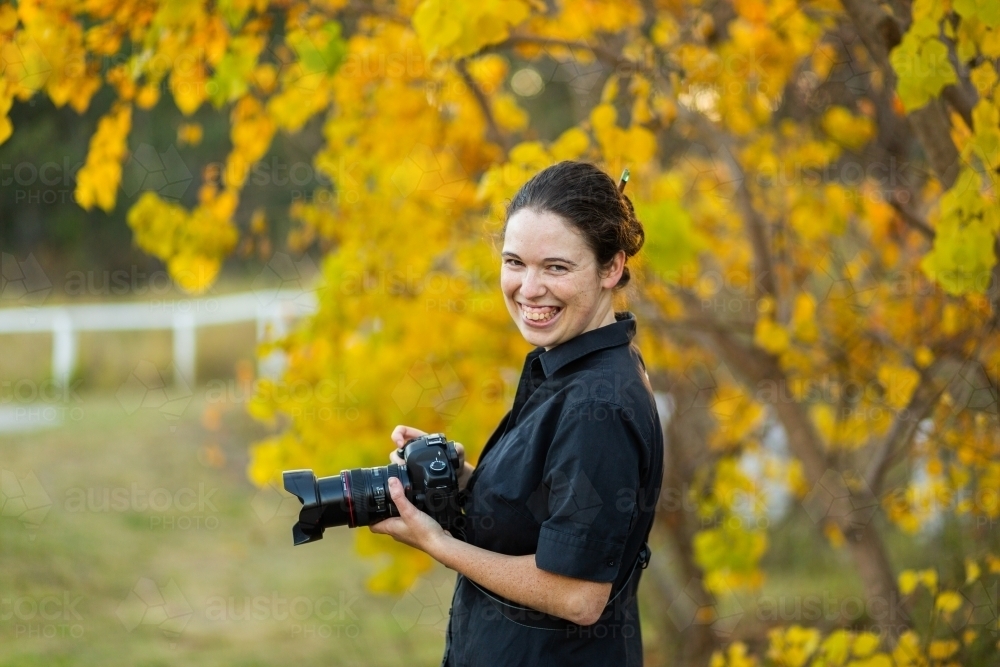 Image of Happy professional photographer with camera during autumn ...