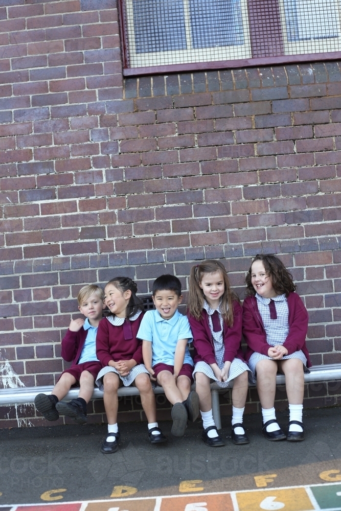Image of Happy school children sitting outside their school building ...