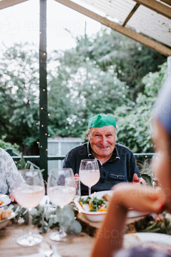 Image of Happy senior man smiling while seated on Christmas dinner ...