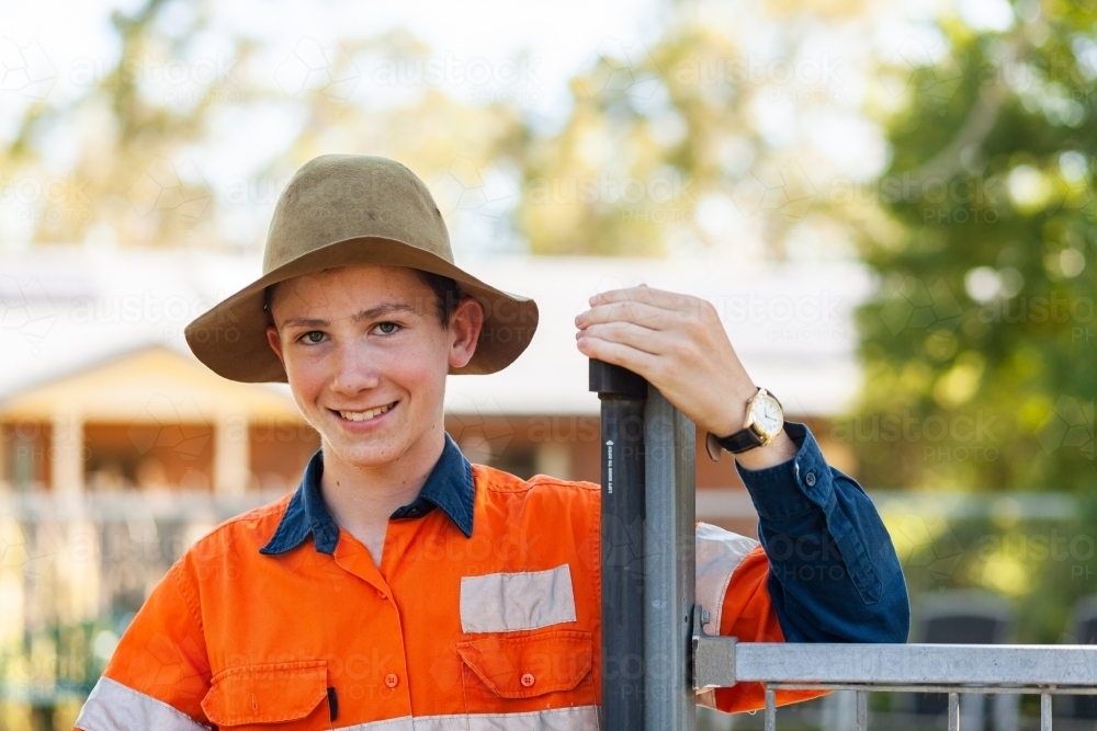 Image of Happy teenage boy in high vis workwear opening pool gate - Austockphoto