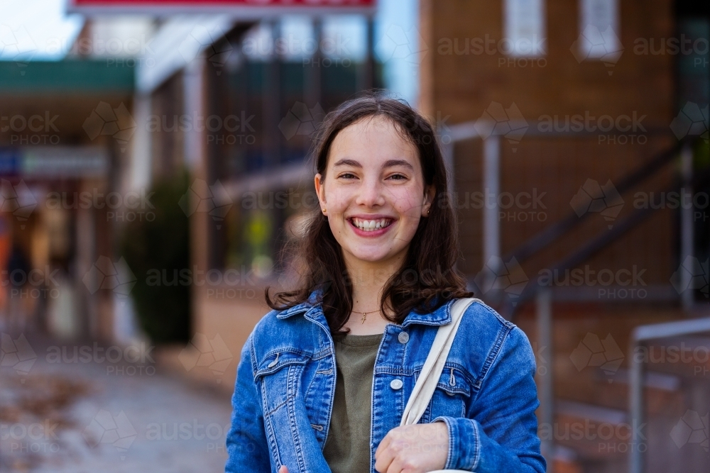 Image of Happy teenaged girl smiling while in urban area of country ...