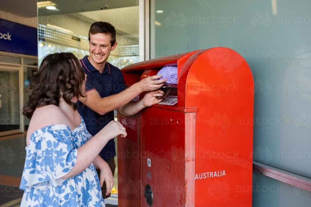 Image of Happy teenager with down syndrome using post office box to ...