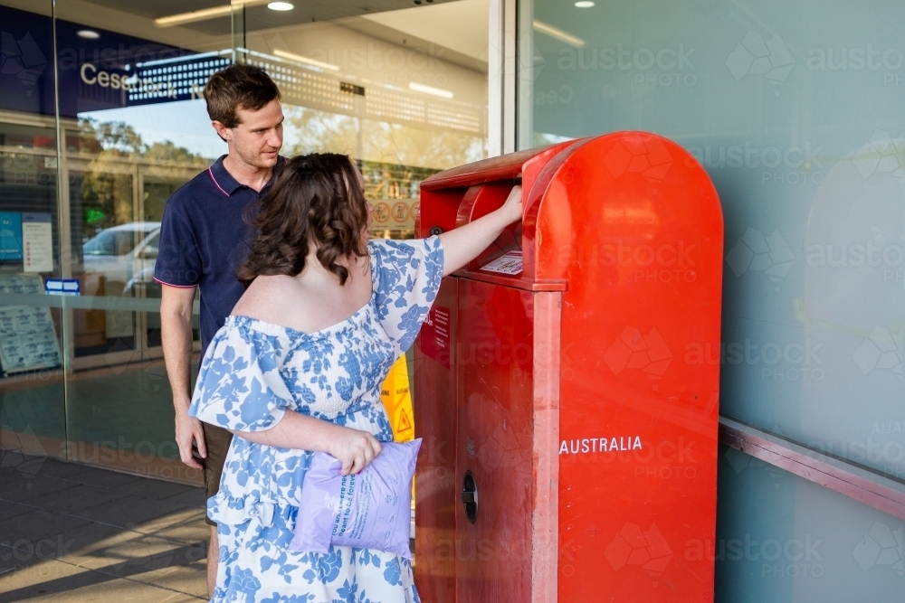Image of Happy teenager with down syndrome using post office box to ...