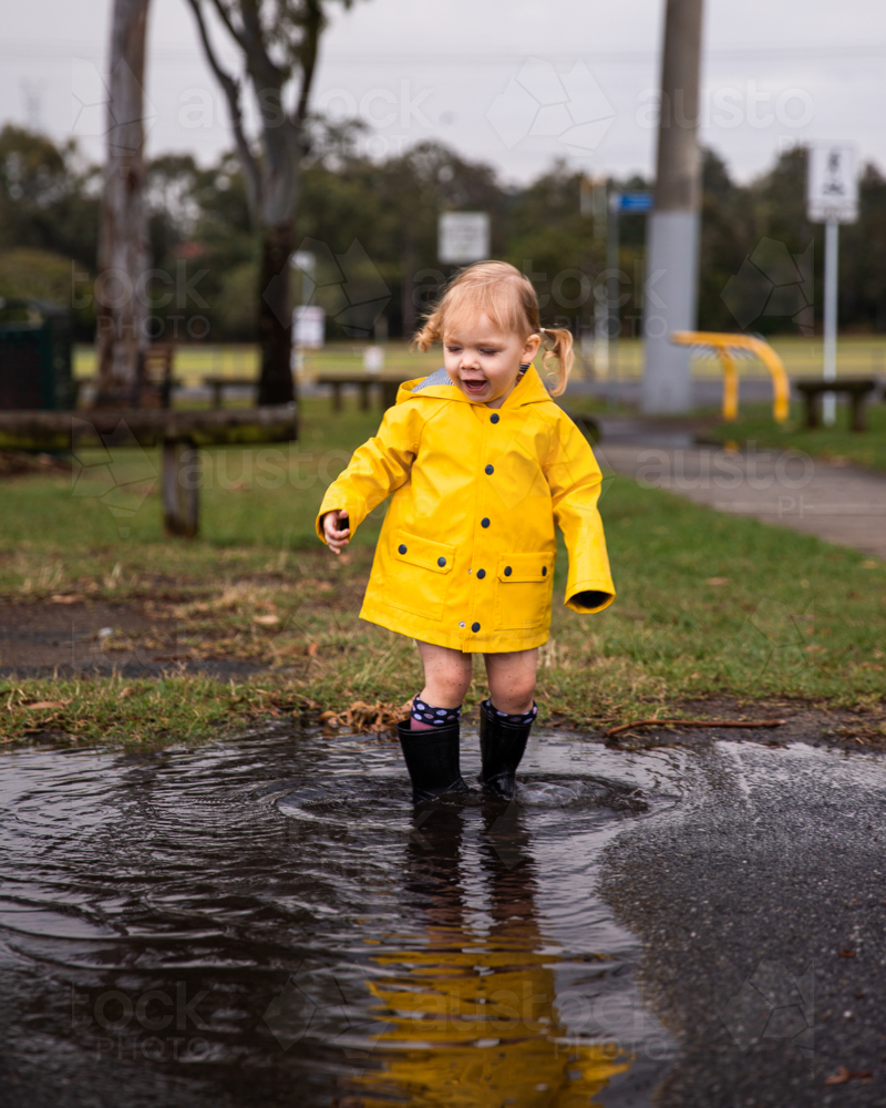 Image of happy toddler standing in a muddy puddle - Austockphoto