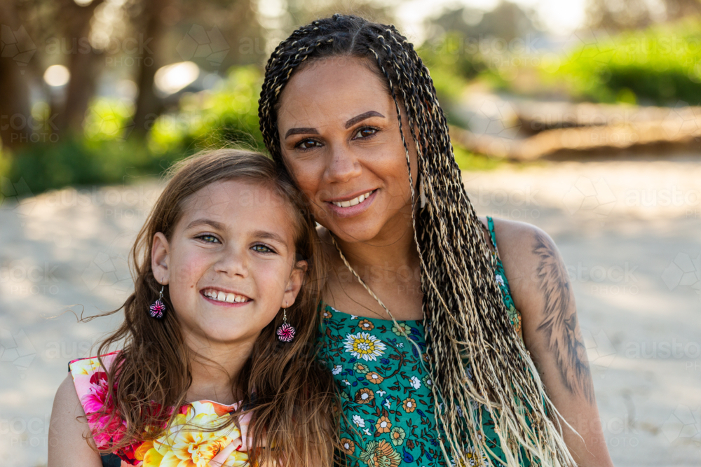 Image of Happy Torres Strait Islander woman with nine year old daughter sitting together outside ...