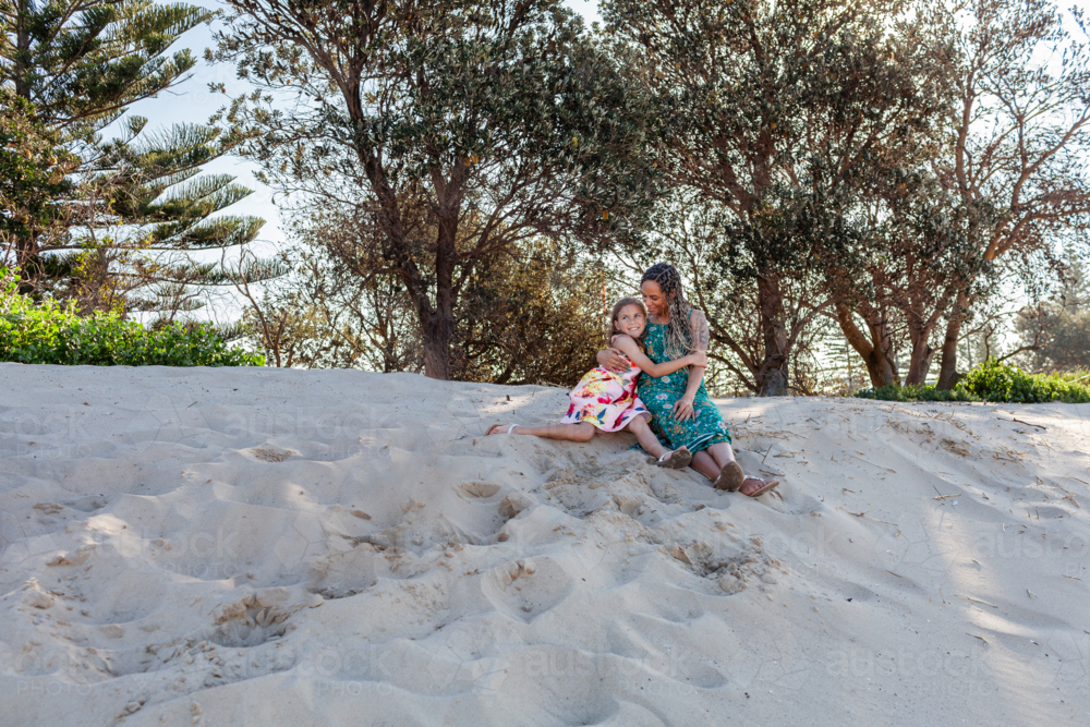 Image of Happy Torres Strait Islander woman with young nine year old daughter sitting together ...