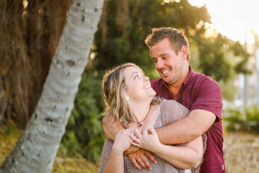 Image of Happy twenty-something couple embracing in golden afternoon ...