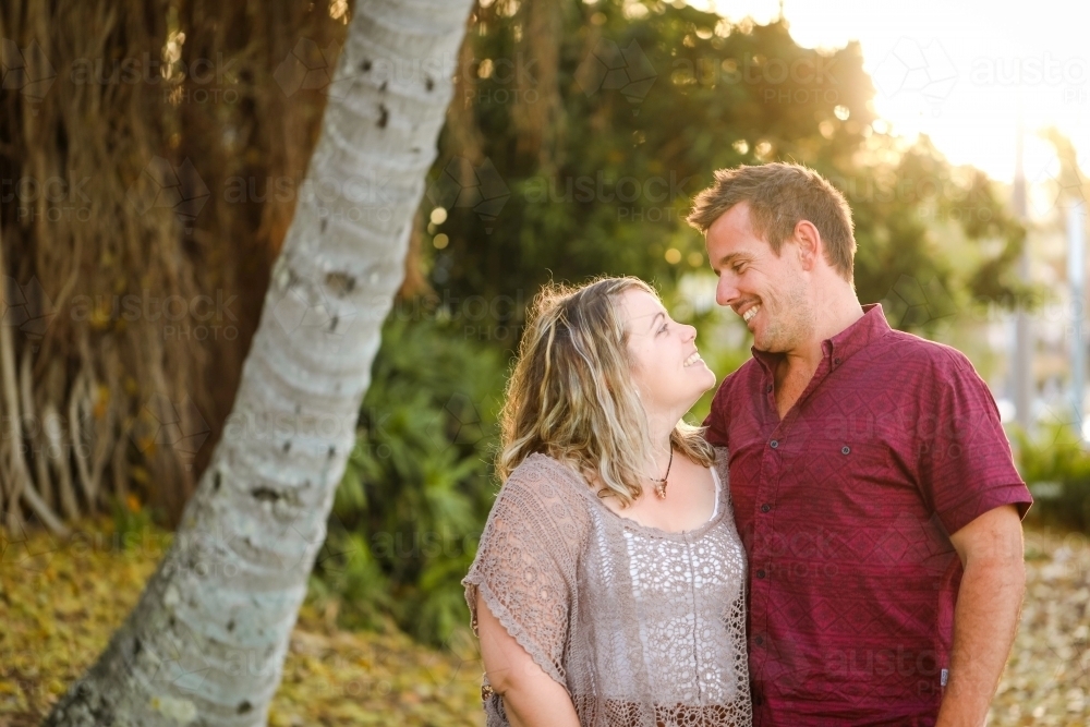 Image of Happy twenty-something couple side hugging in golden afternoon ...