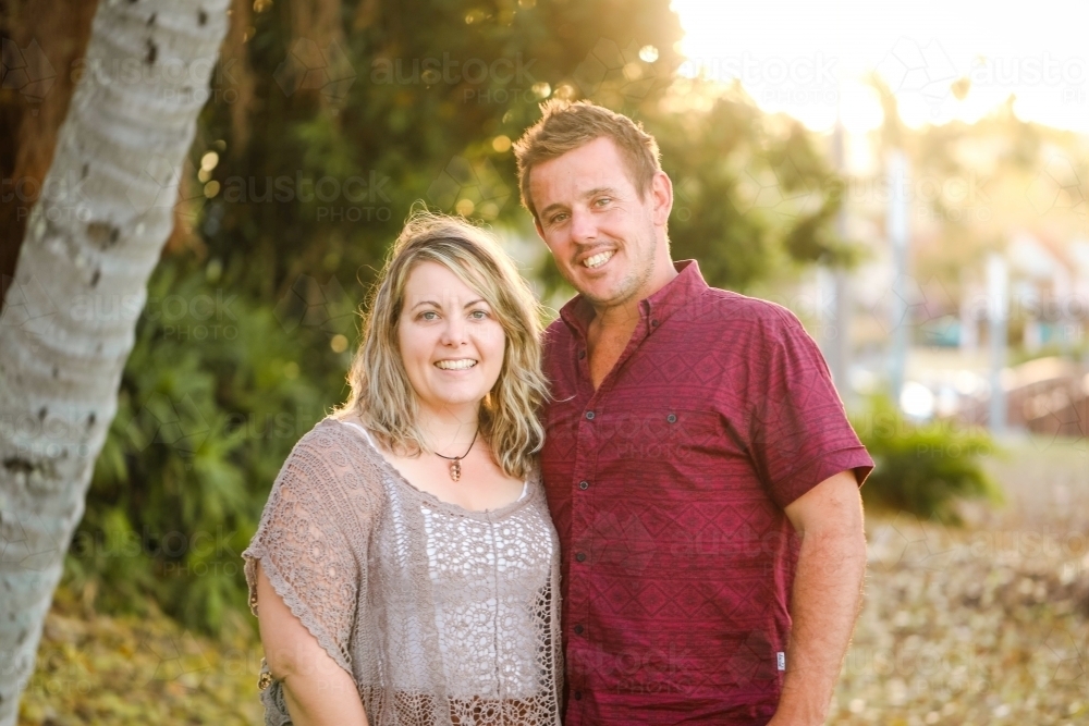Image of Happy twenty-something couple standing together in golden ...