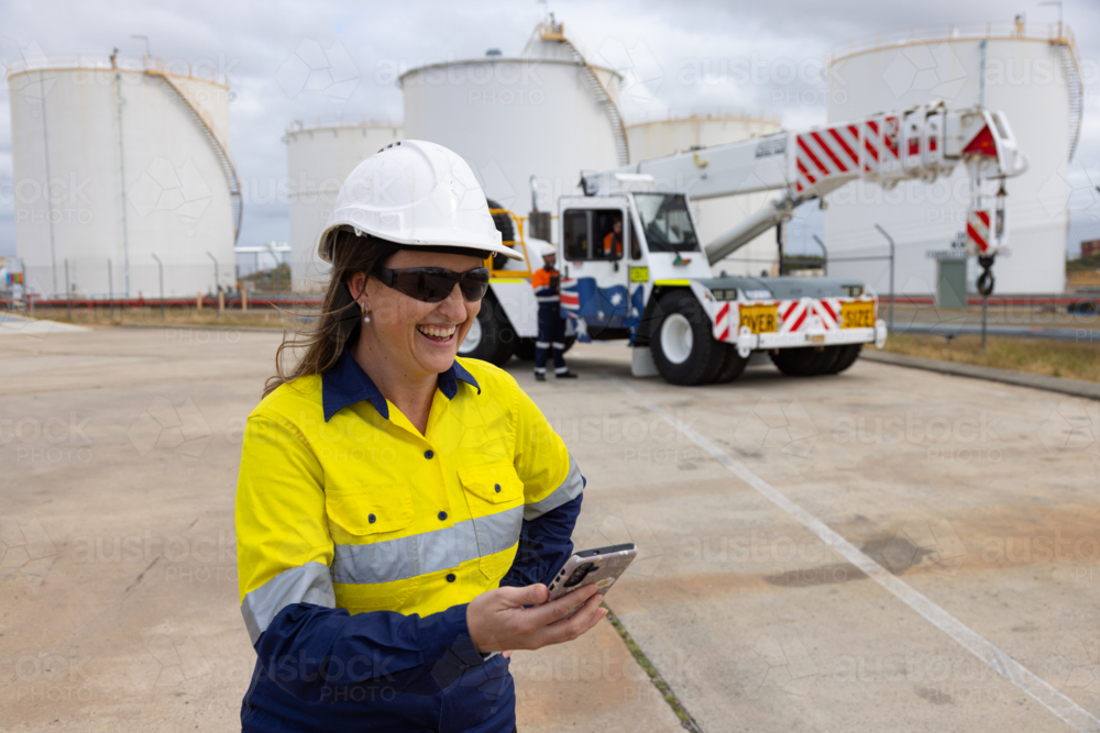 Image of Happy woman in reflective clothing holding her mobile phone in ...