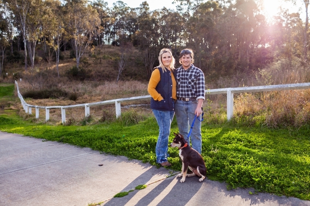 Image of Happy young Aussie couple and their kelpie pup - Austockphoto